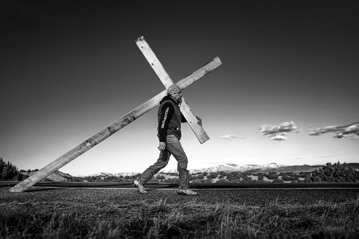 Photos - A man carries a large wooden cross down N.M. 503 for the ...